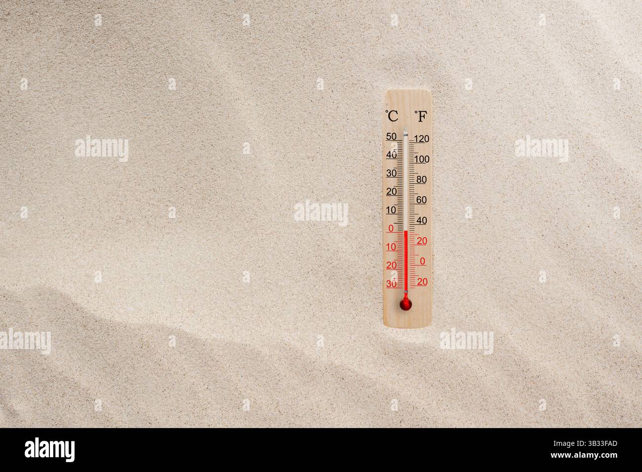 Wooden celsius and fahrenheit scale thermometer in the sand. Ambient ...
