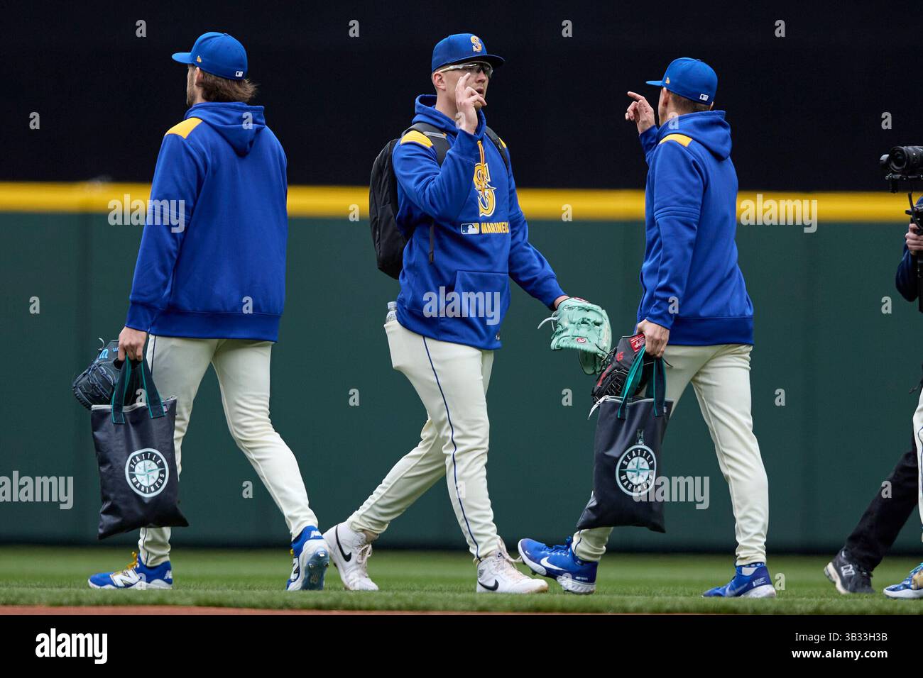 Seattle Mariners starting pitcher Logan Evens, center, makes his way to ...