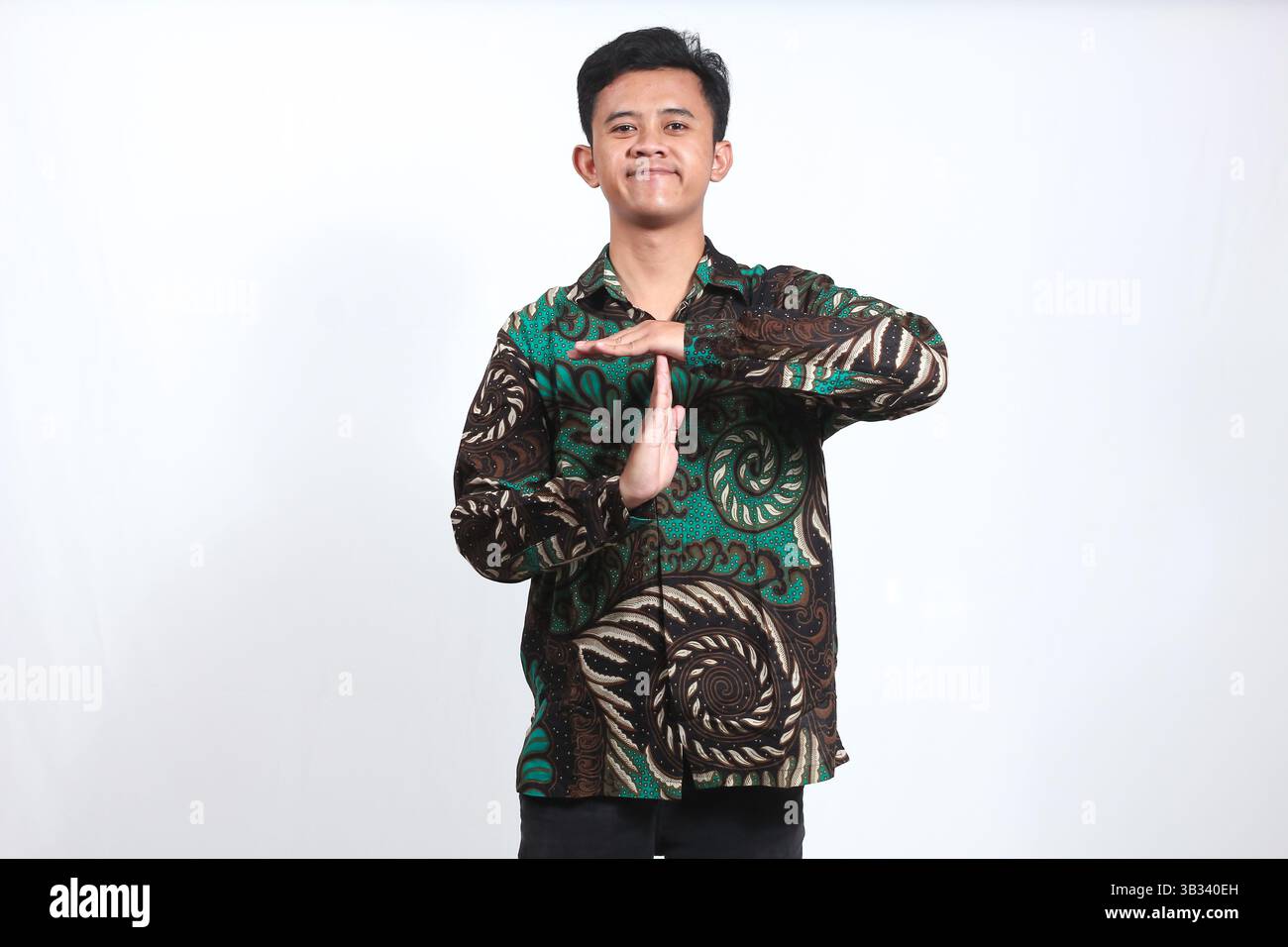 Asian man wearing batik shirt asking for extra time by pointing hand ...
