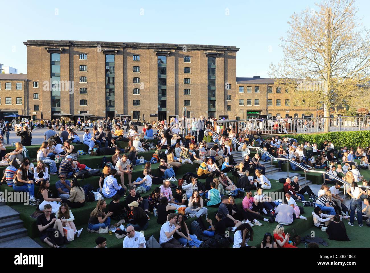People on the steps by Regents Canal on Granary Square, enjoying spring ...