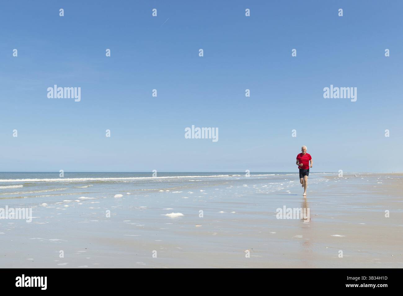 Elder man running at the beach Stock Photo - Alamy