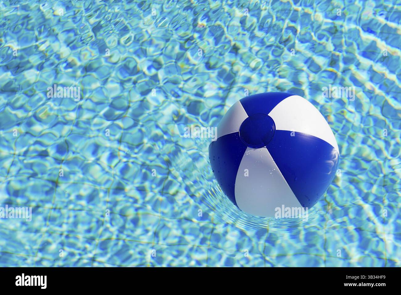 Blue and white beach ball in clear water of swimming pool Stock Photo ...