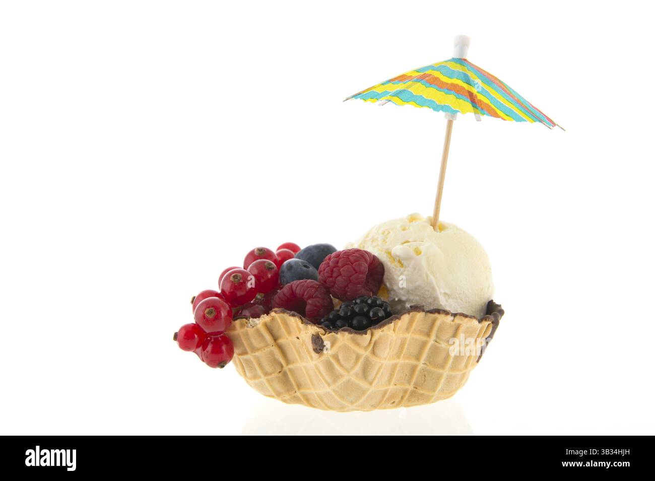 Cup from cookie with vanilla ice and fresh fruit with parasol isolated ...
