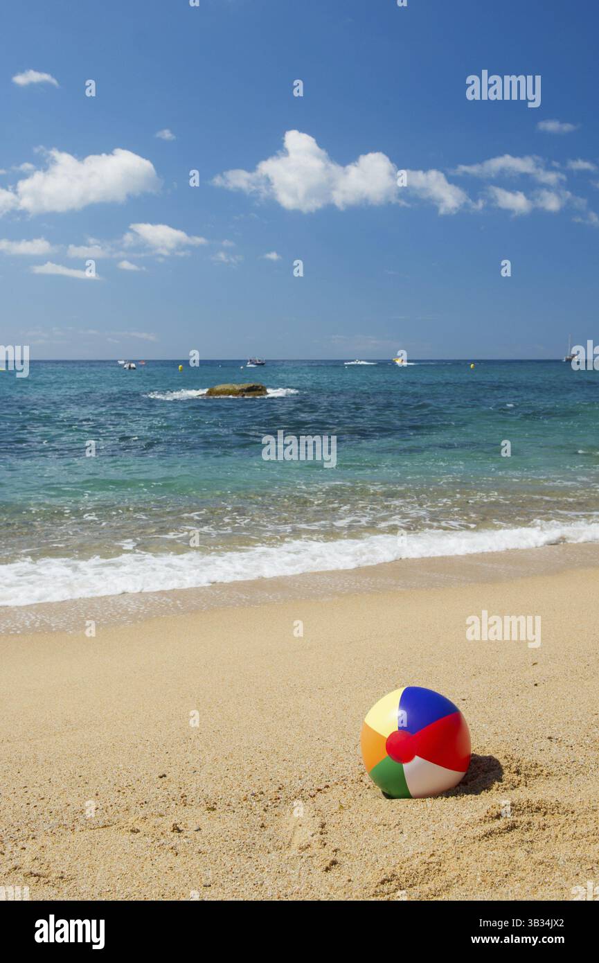 Inflatable beach ball in the sand near the water line at the Spanish ...