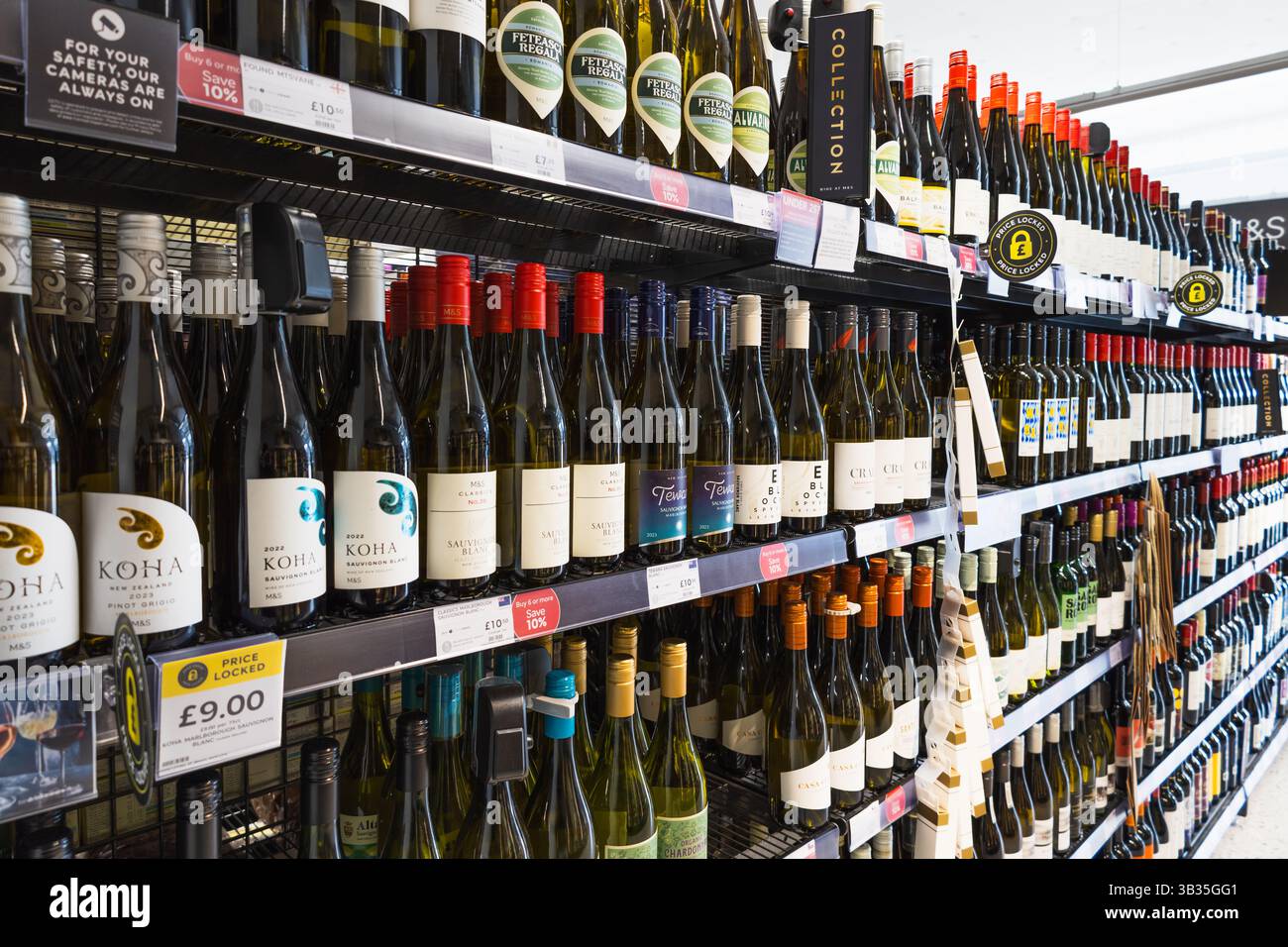 The grocery store wine aisle showcases bottles of wine varieties ...