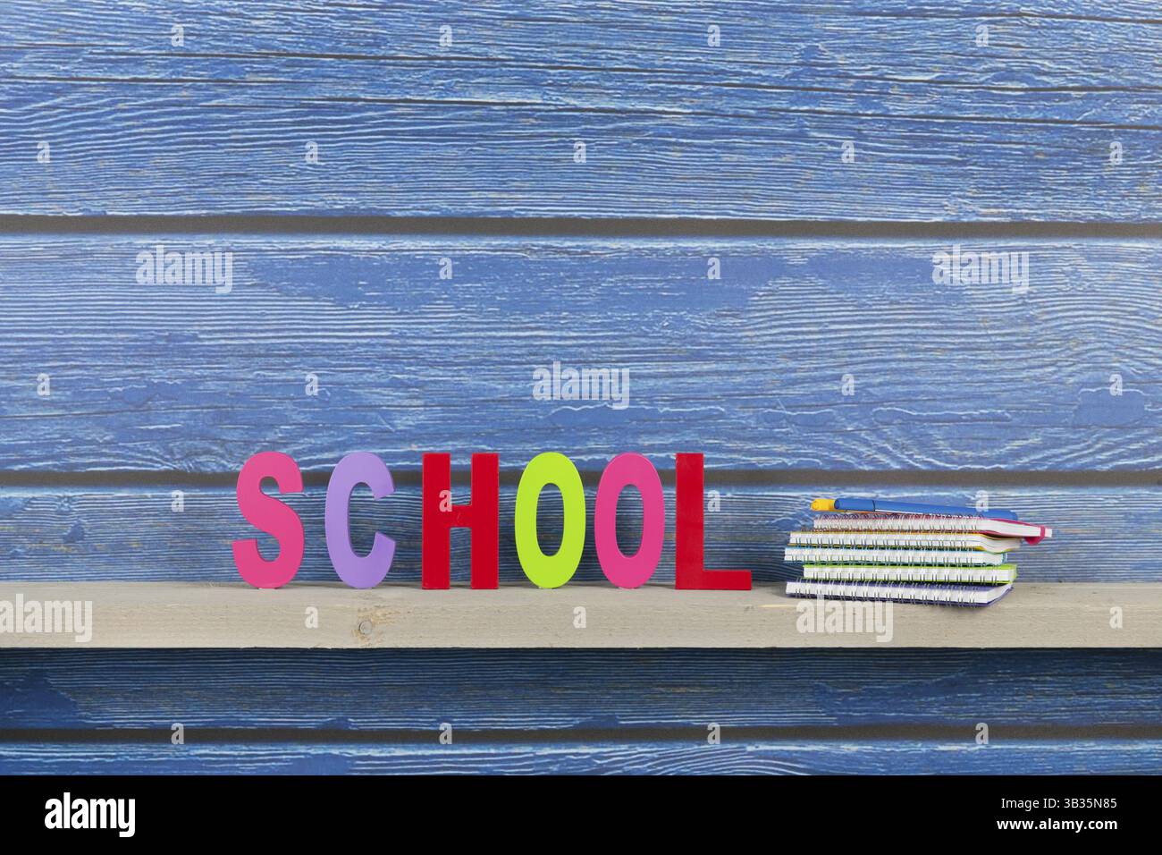 School in colorful letters and notebooks with vintage blue wooden wall ...