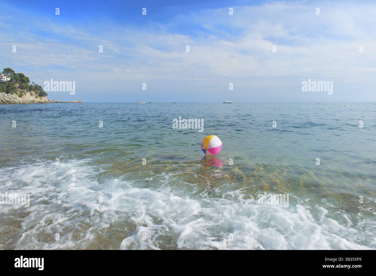 Colorful inflatable beach ball playing with the surf and the sea Stock ...