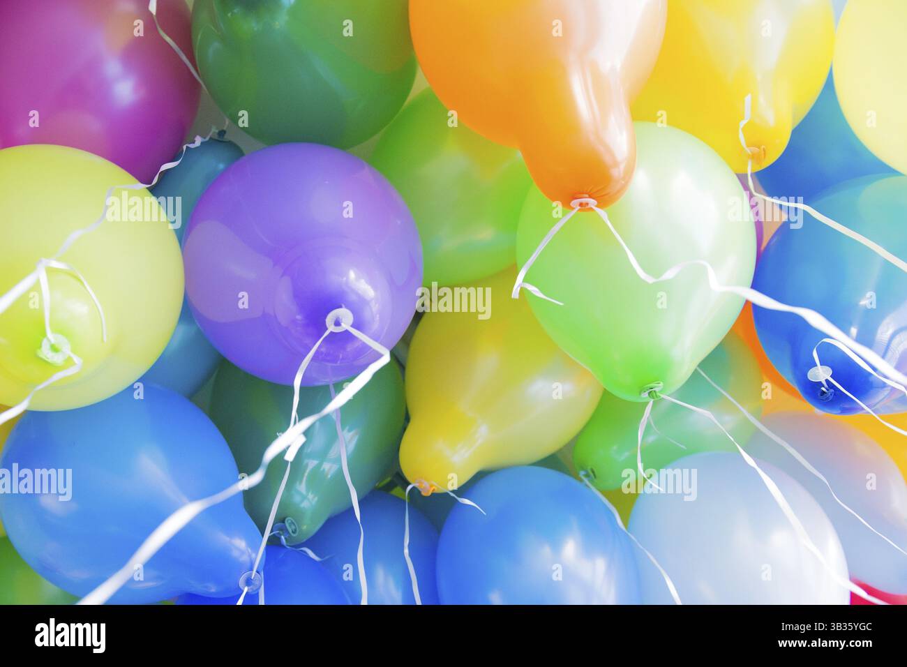Many colorful balloons with ribbons Stock Photo - Alamy