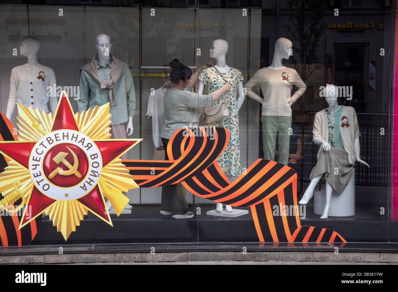 Moscow, Russia. 28th of April, 2025. A woman decorates the window of a ...