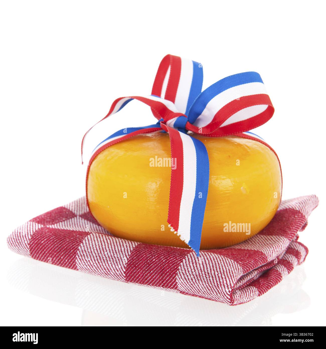 Two whole dutch cheeses with ribbon in flag colors on checked napkin ...
