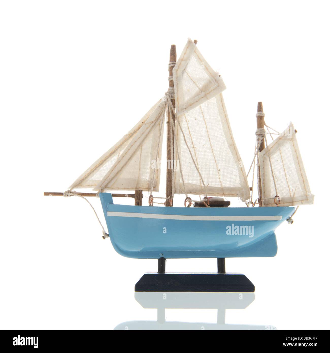 Miniature blue sail boat isolated over white background Stock Photo - Alamy