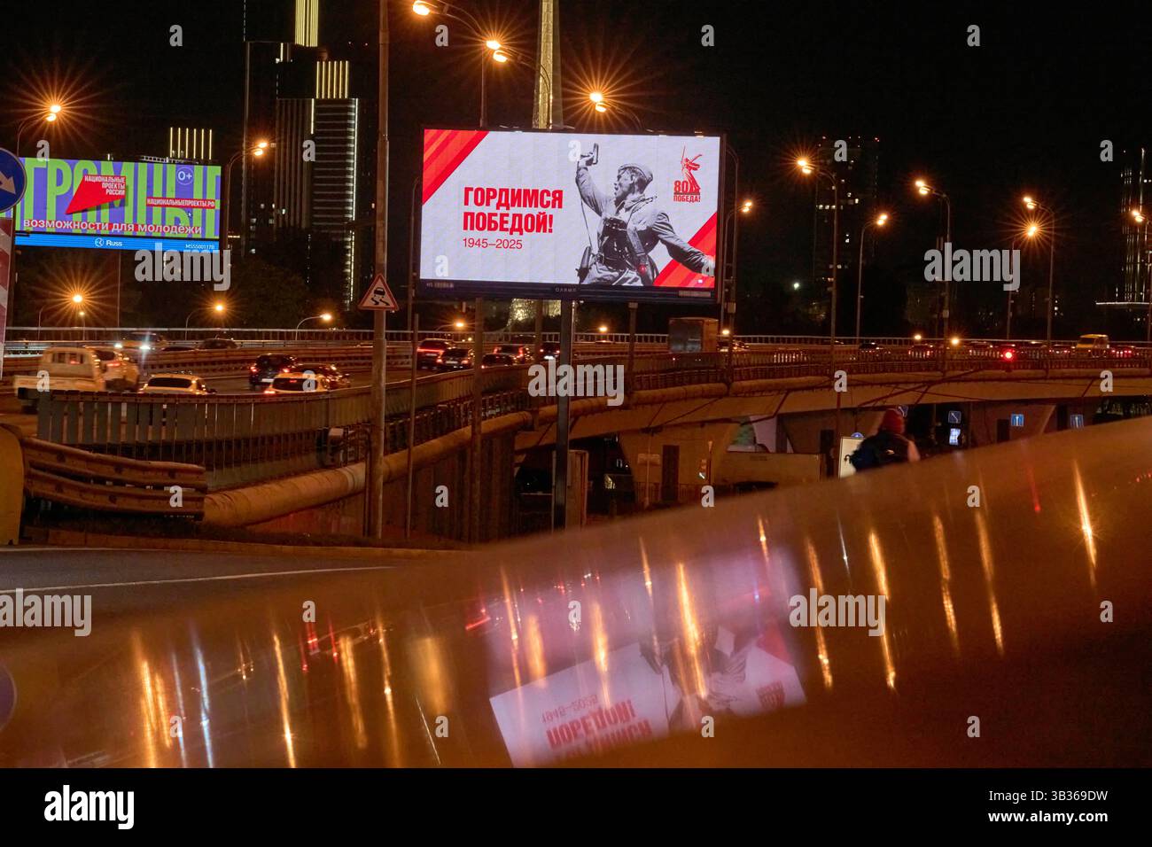 Cars pass an electronic billboard showing the photograph Kombat (a ...