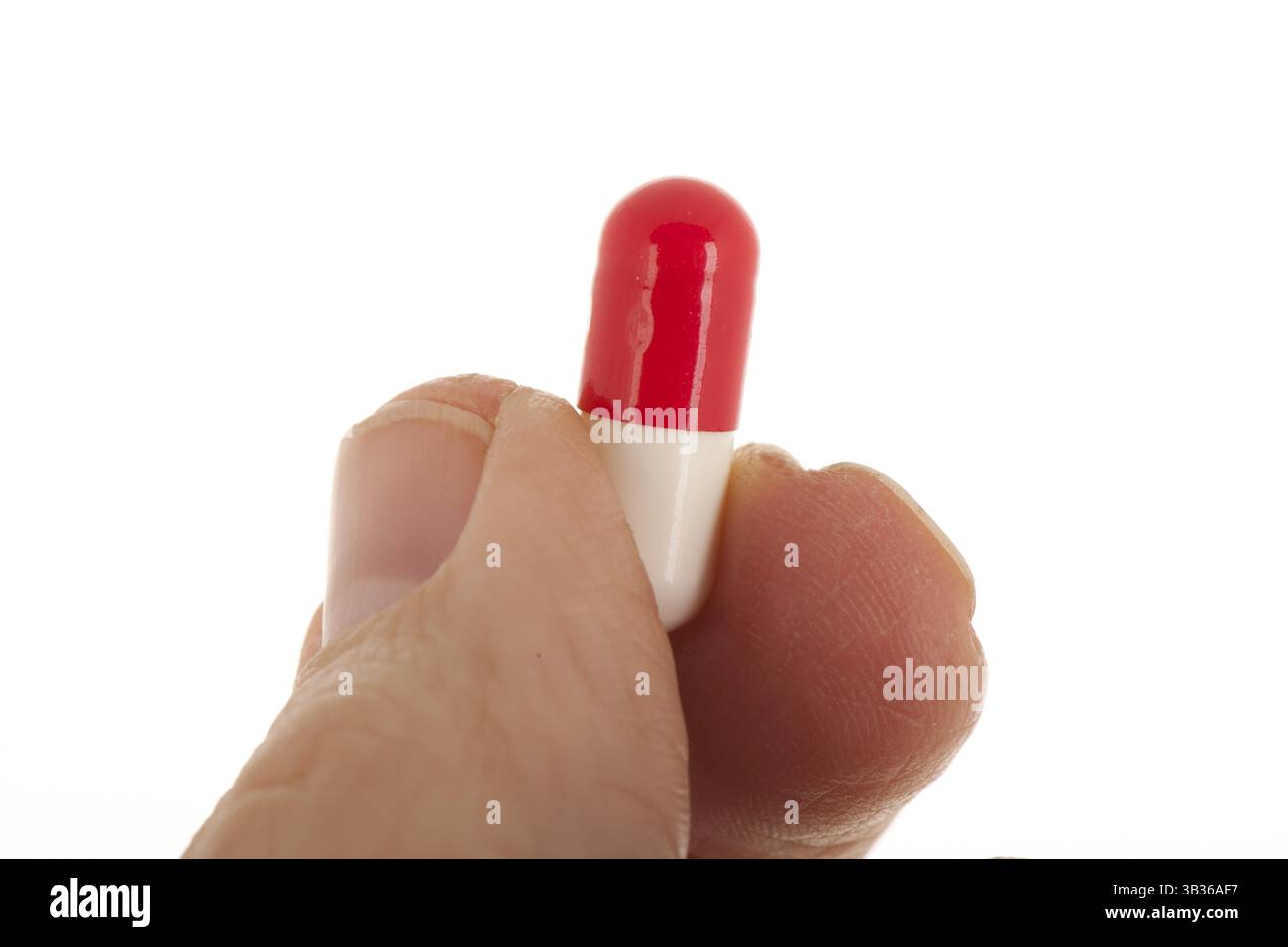 Old hand with capsule pill in red and white Stock Photo - Alamy