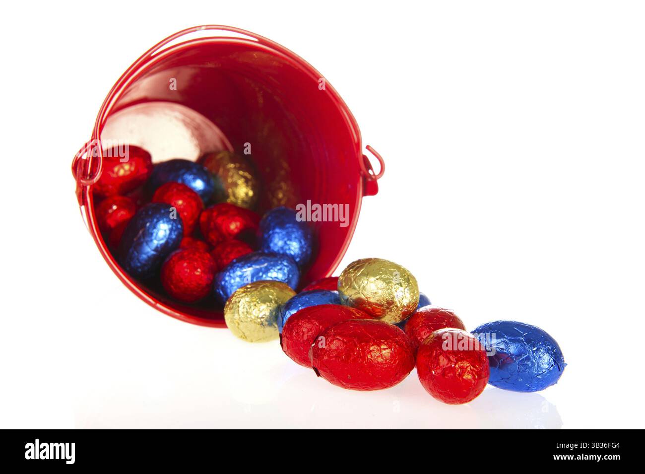 Fallen red bucket with chocolate easter eggs Stock Photo - Alamy