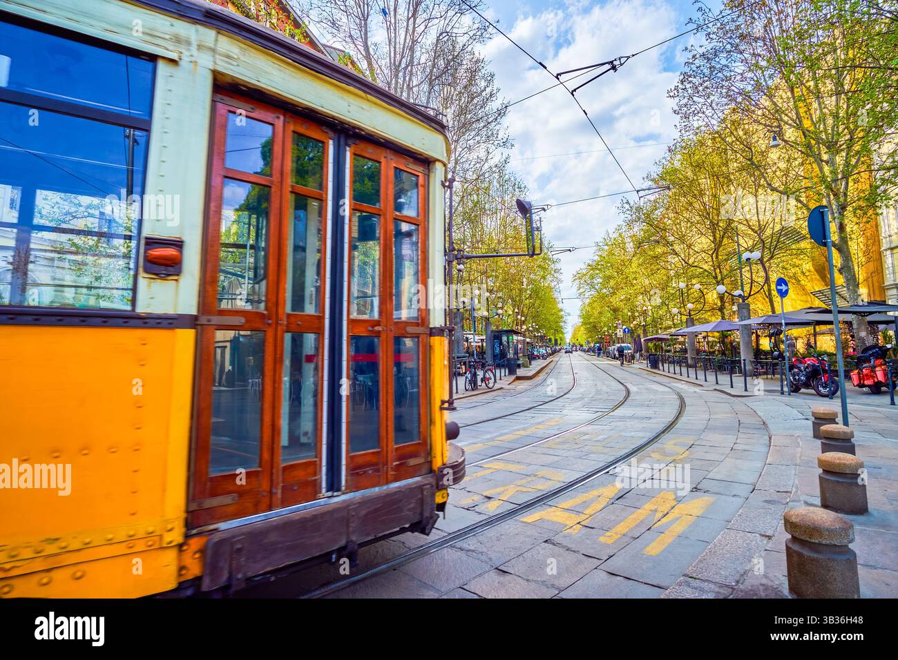 Vintage tram rides on tree-lined Corso Sempione avenue with lovely ...