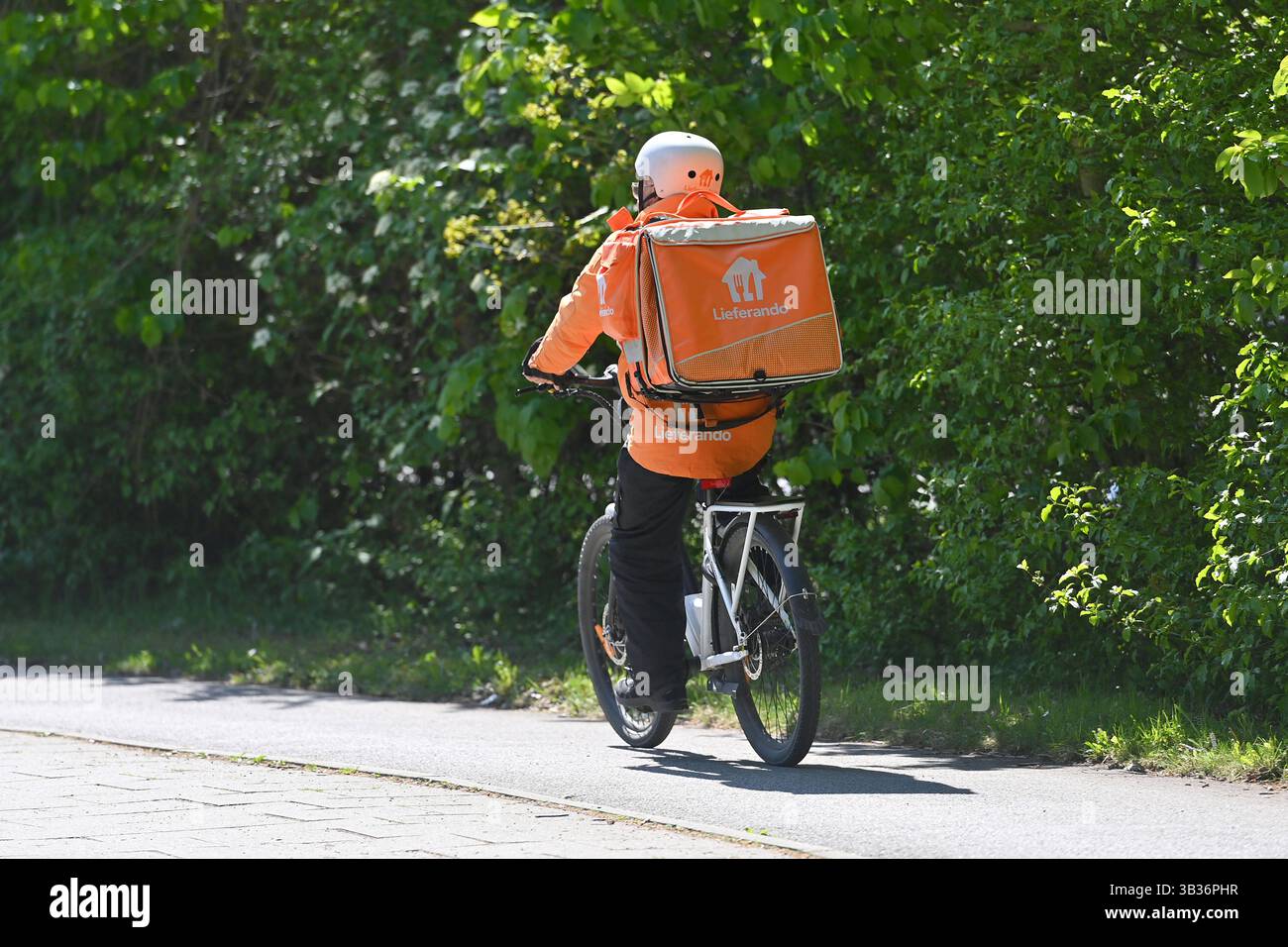 Ein Fahrer,Radfahrer vom LieferdiensLieferandeo faehrt mit dem Fahrrad ...