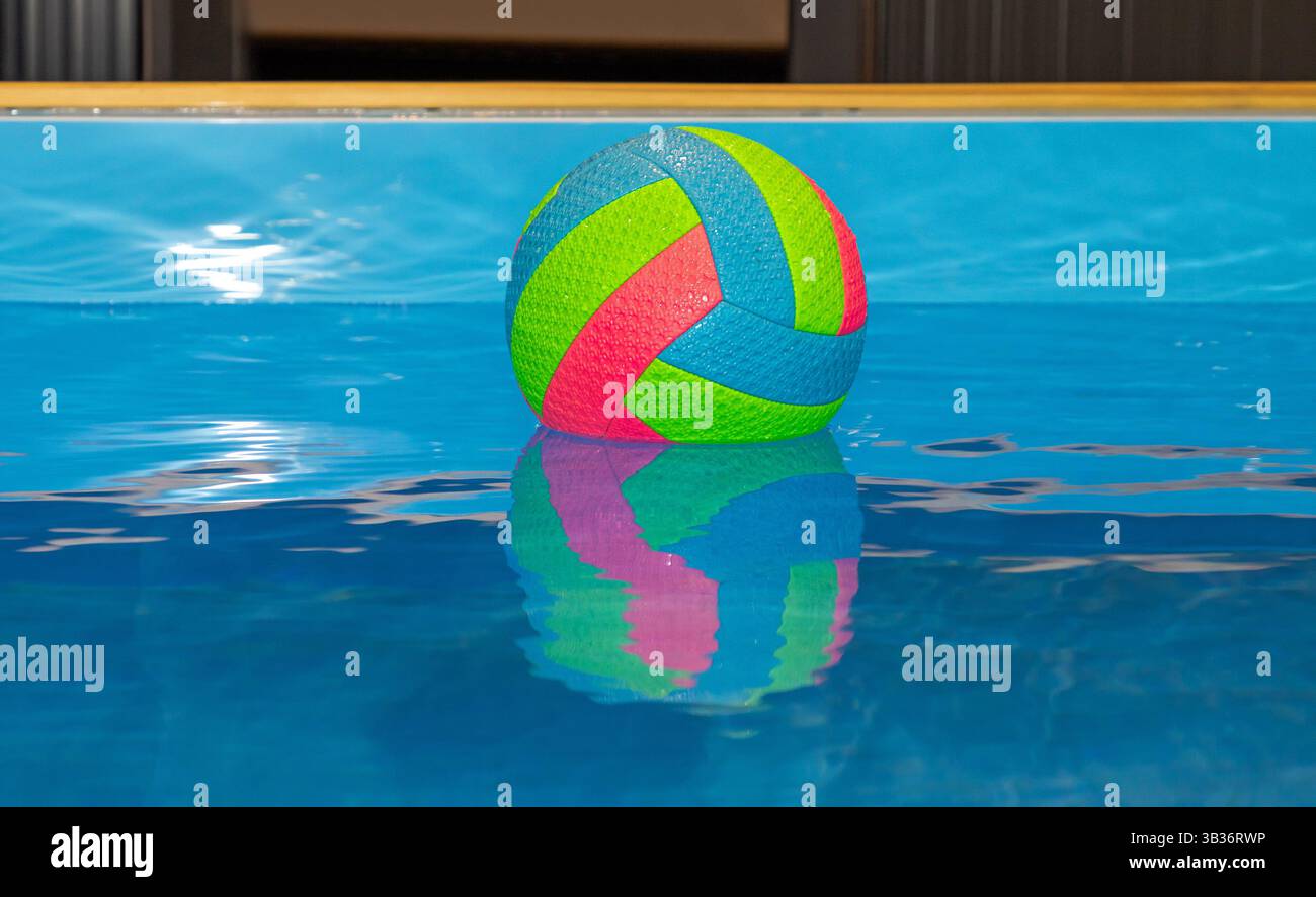 Colorful plastic ball floating on a surface of water in swimming pool ...