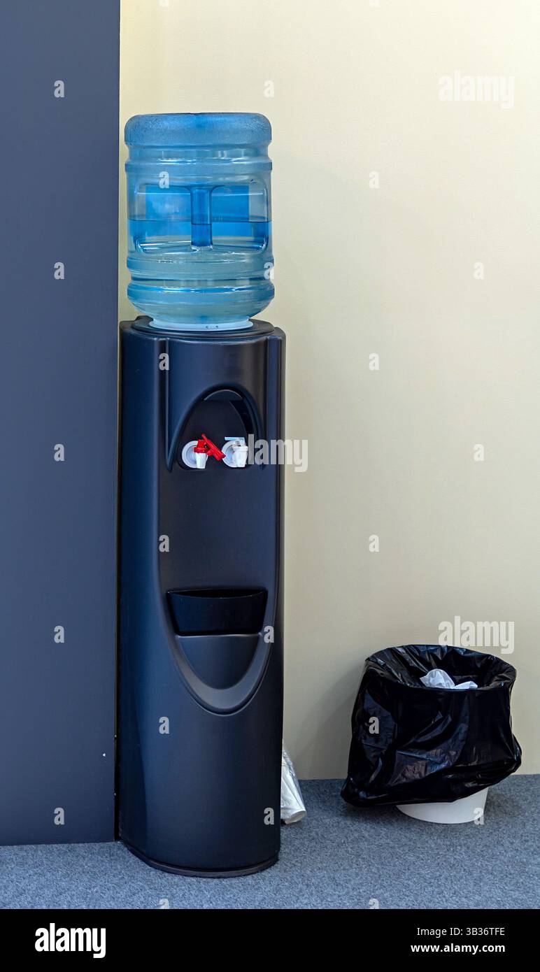 Water cooler dispenser with trash bin inside the office interior Stock ...