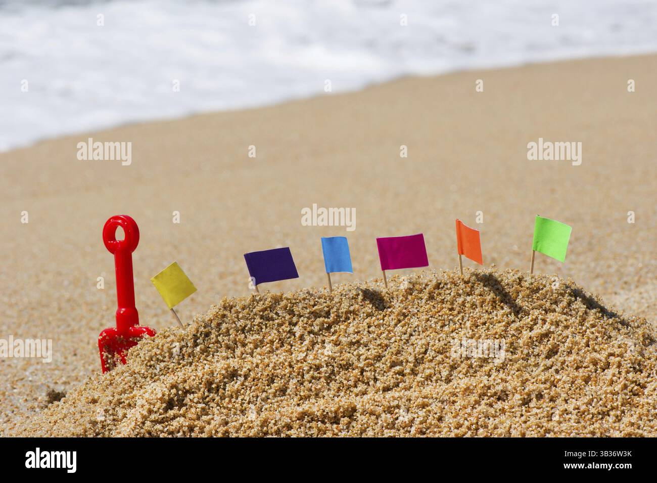 Sand castle with colorful flags at the beach Stock Photo - Alamy