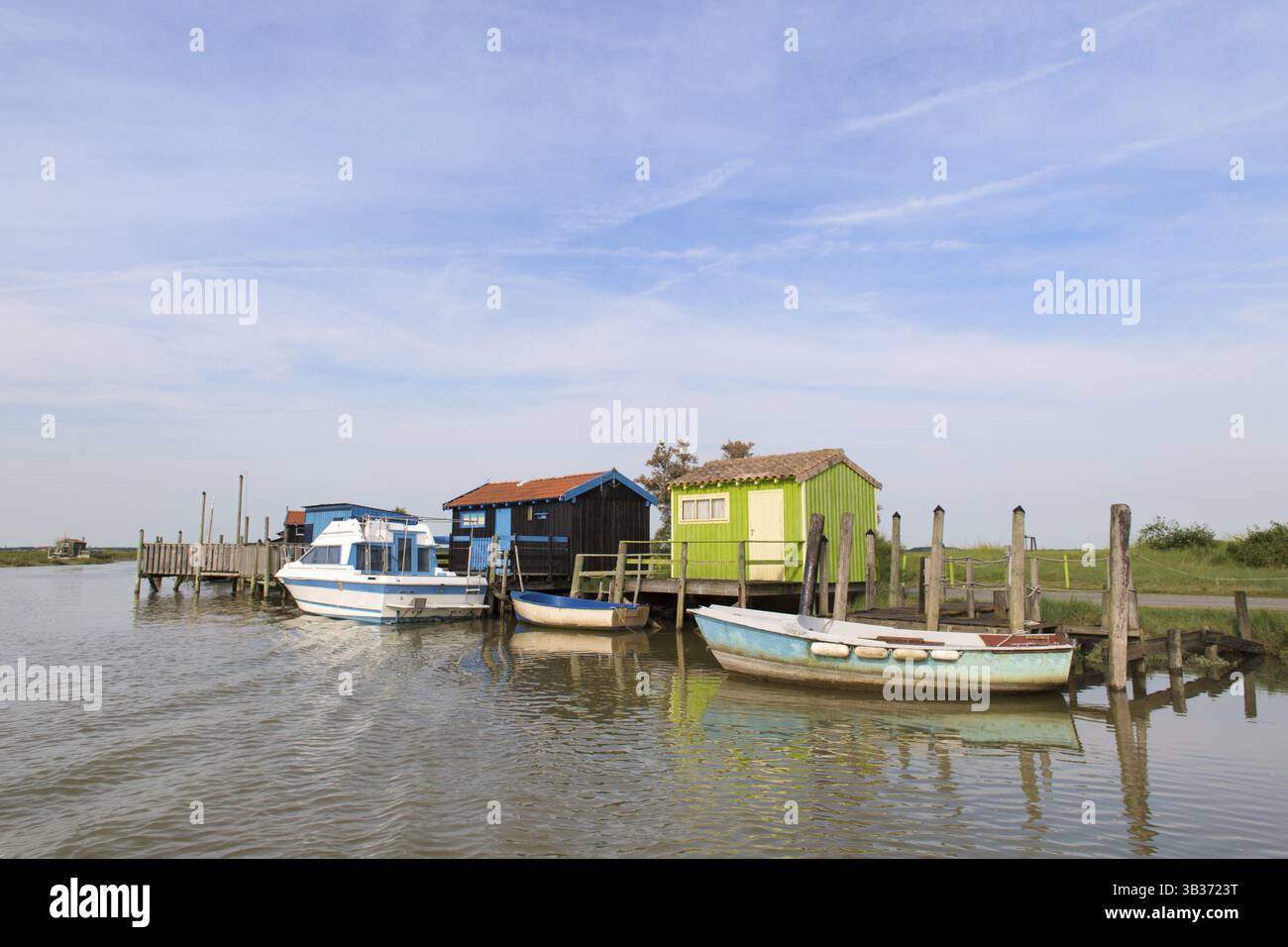 French wooden oyster huts at boat dock in landscape in the France ...