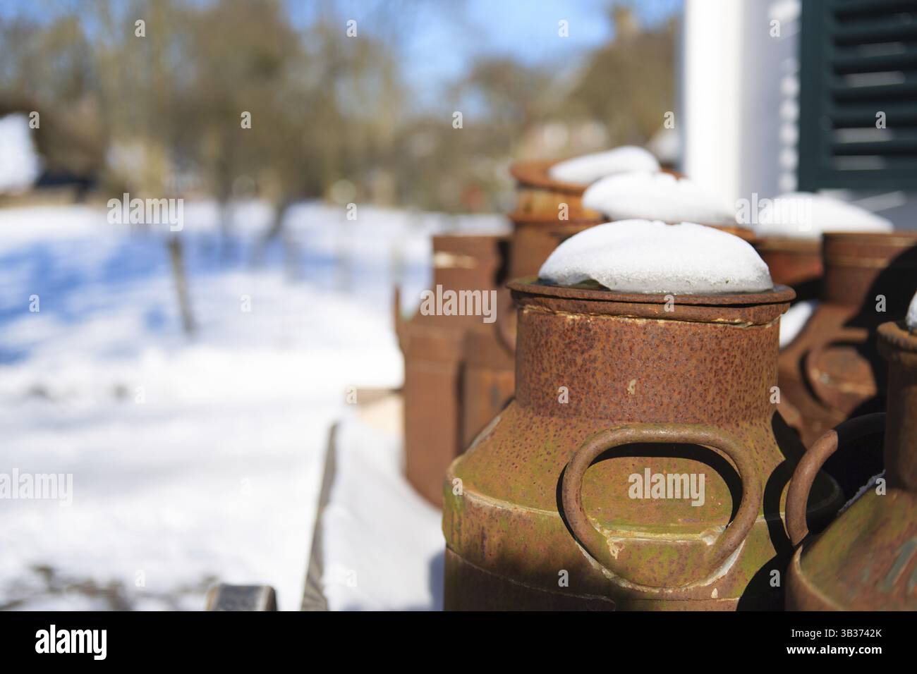 Typical Dutch rusty milk cans in snow Stock Photo - Alamy