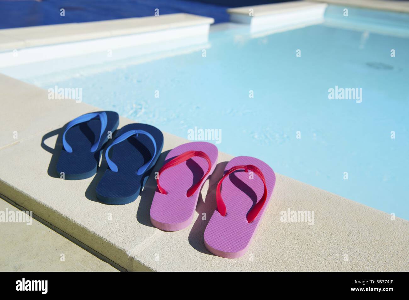 Flip flops for him and her at the swimming pool Stock Photo - Alamy