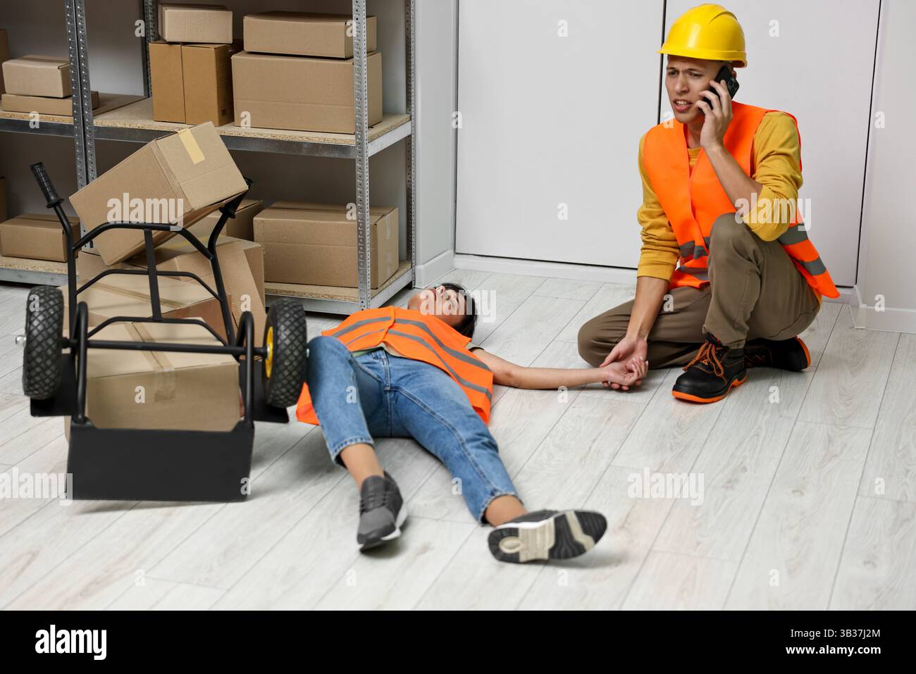 Accident at work. Man calling ambulance for his unconscious colleague ...