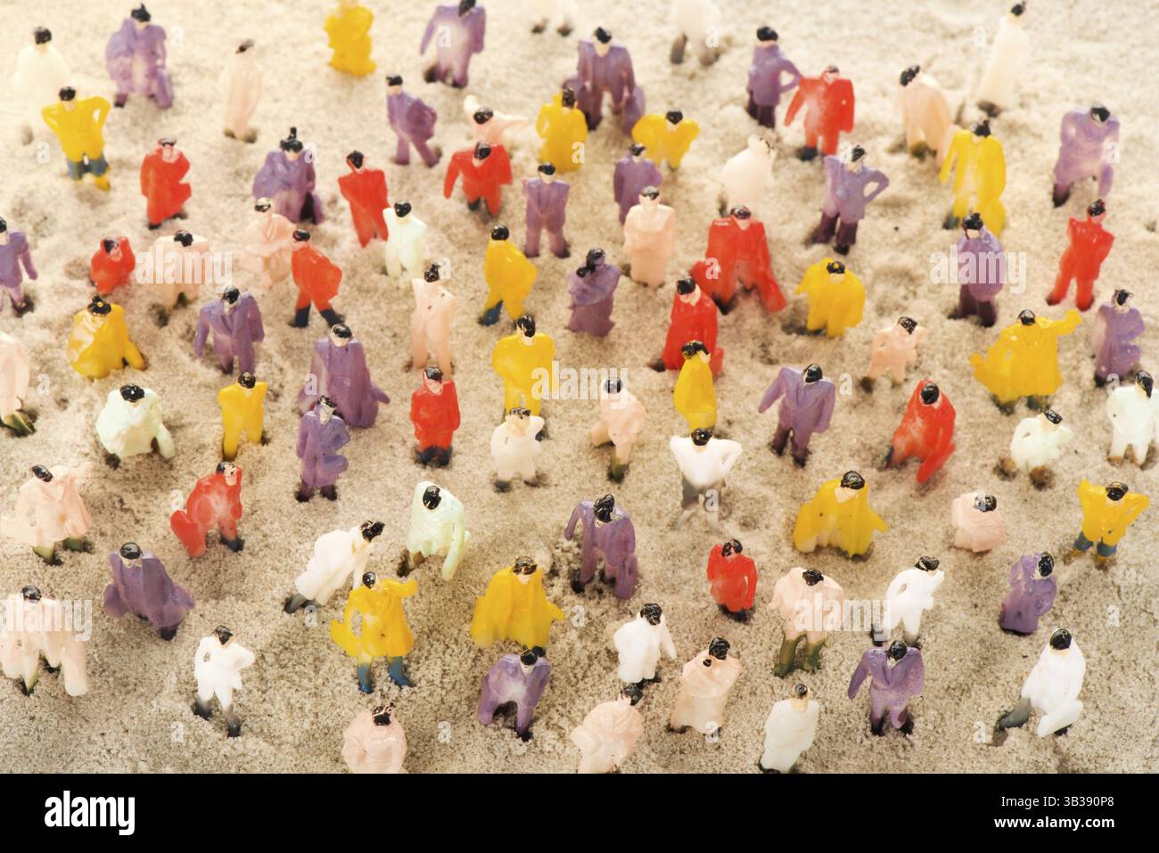 Crowd of many little figurines in sand Stock Photo - Alamy