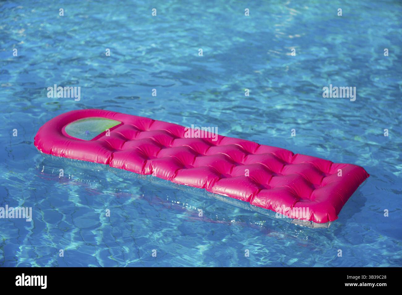 Floating pink and green air mattress in swimming pool Stock Photo - Alamy