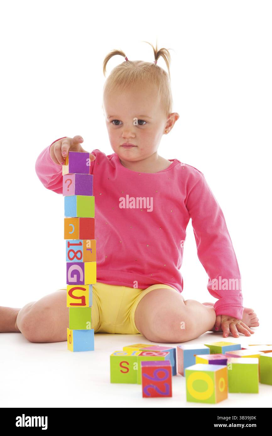 Portrait toddler girl playing with blocks isolated over white ...
