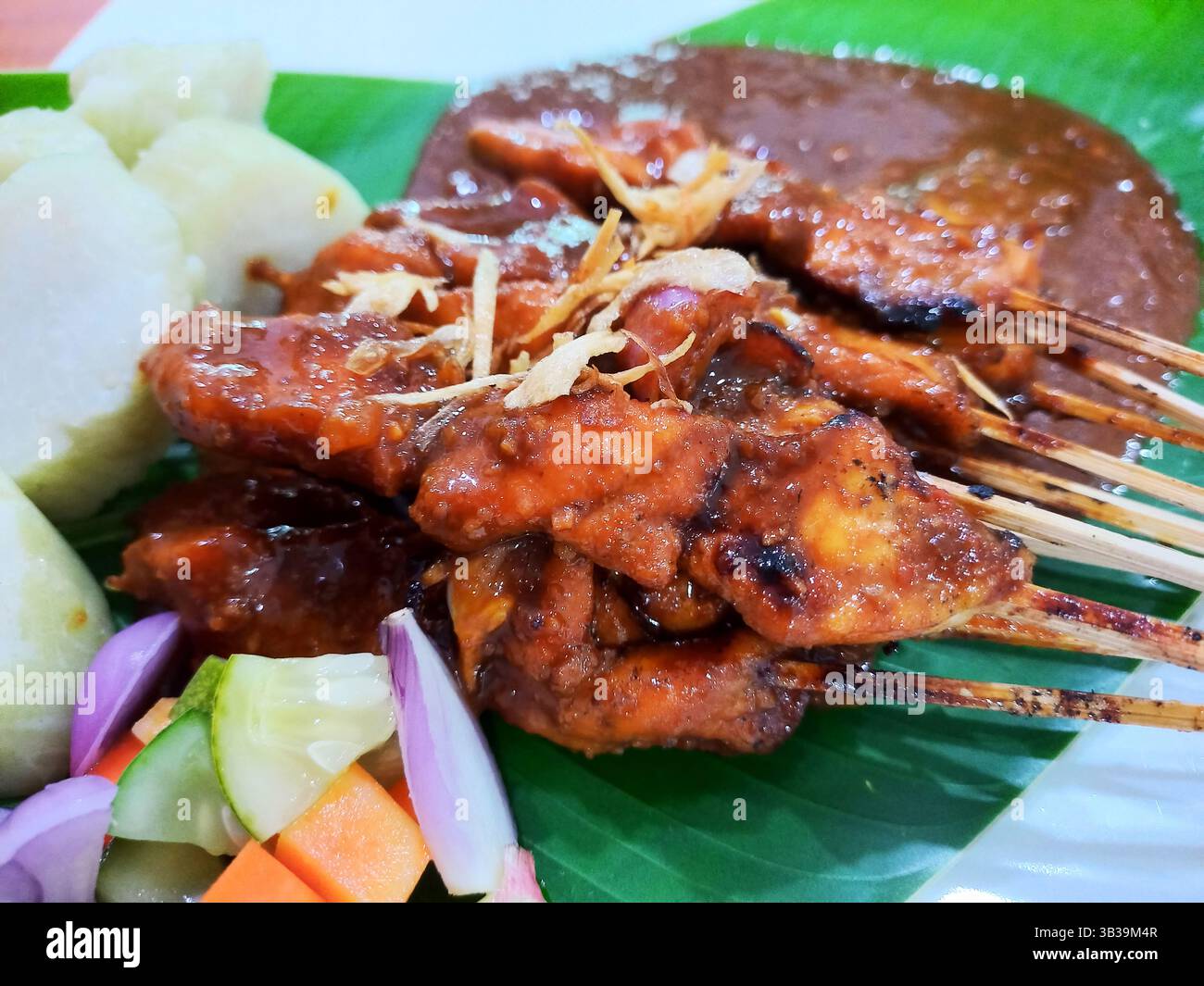 Indonesian Sate Ayam or Chicken Satay with lontong rice cake served on ...