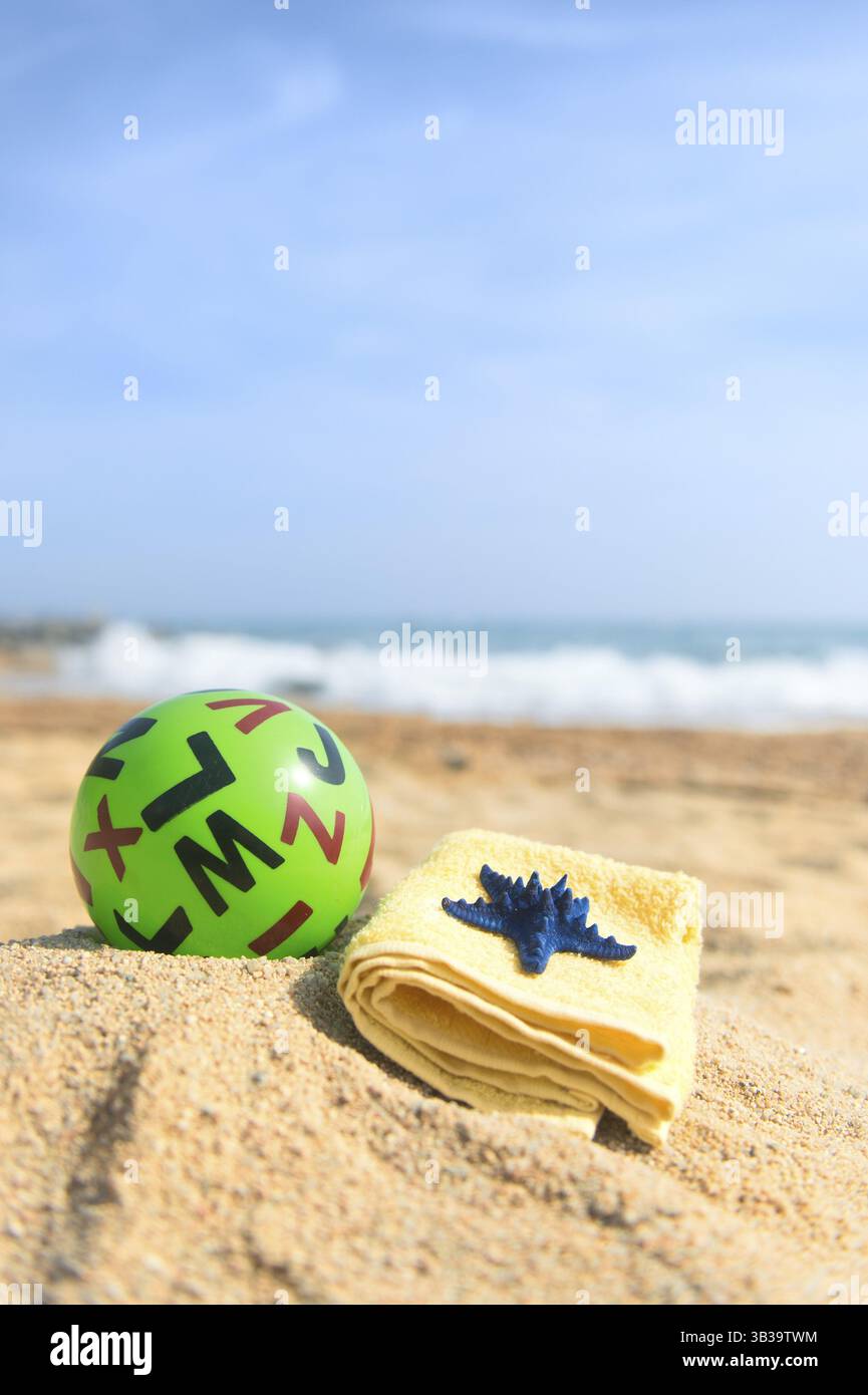 Green toy ball with letters at the beach Stock Photo - Alamy