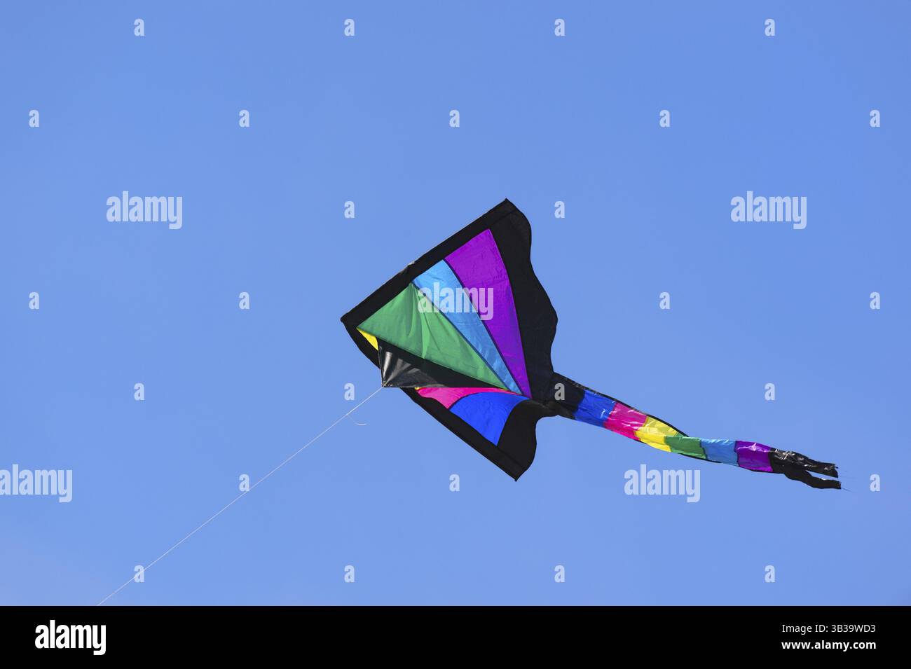 Colorful kite high in the air Stock Photo - Alamy