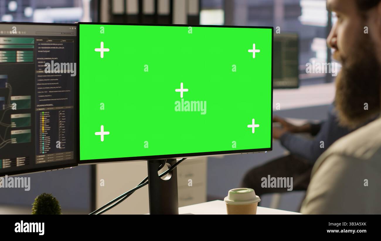 Man working with machine learning tech on green screen computer ...