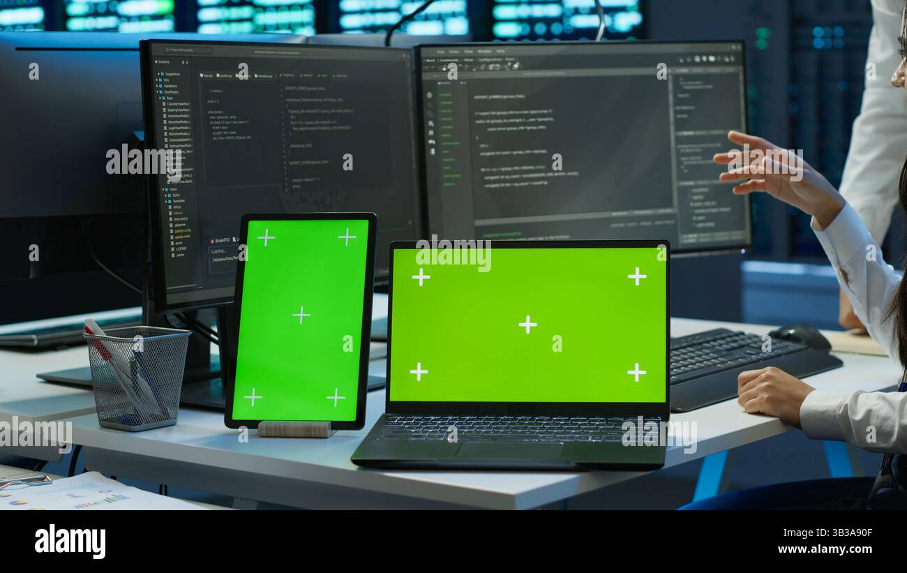 Engineer working with mockup laptop and tablet in data center used for managing gear energy ...
