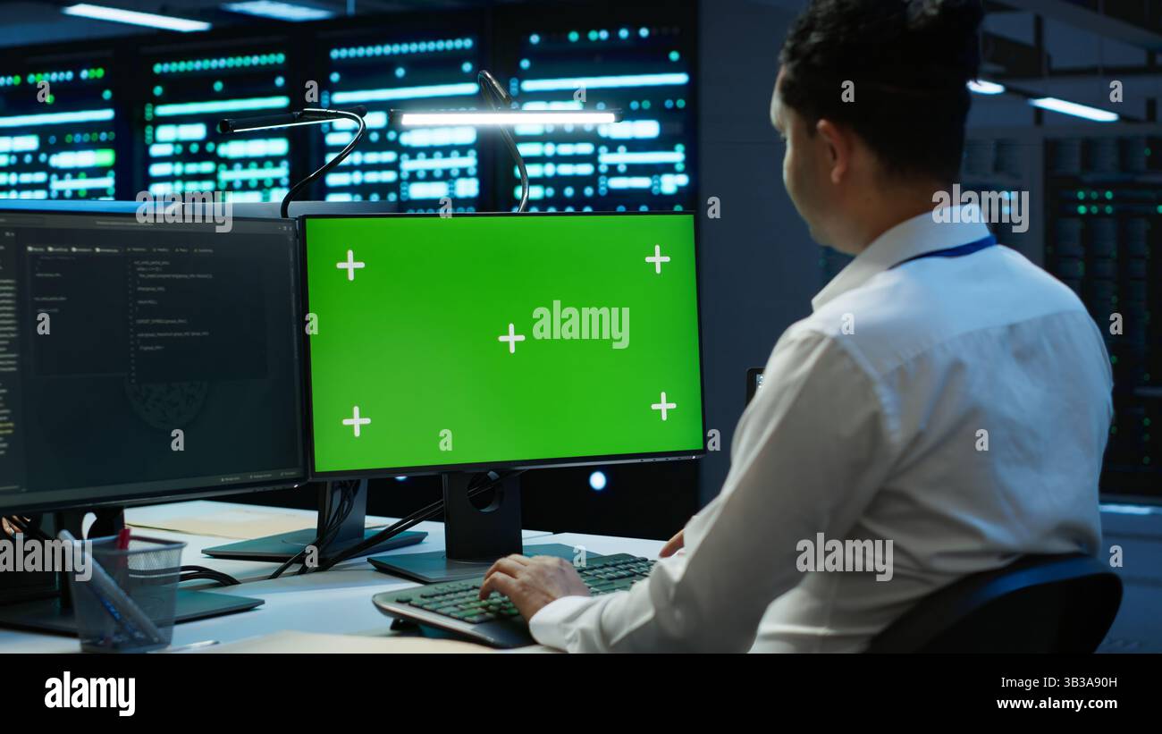 Programmer in data center managing and maintaining databases using mockup PC, ensuring data ...