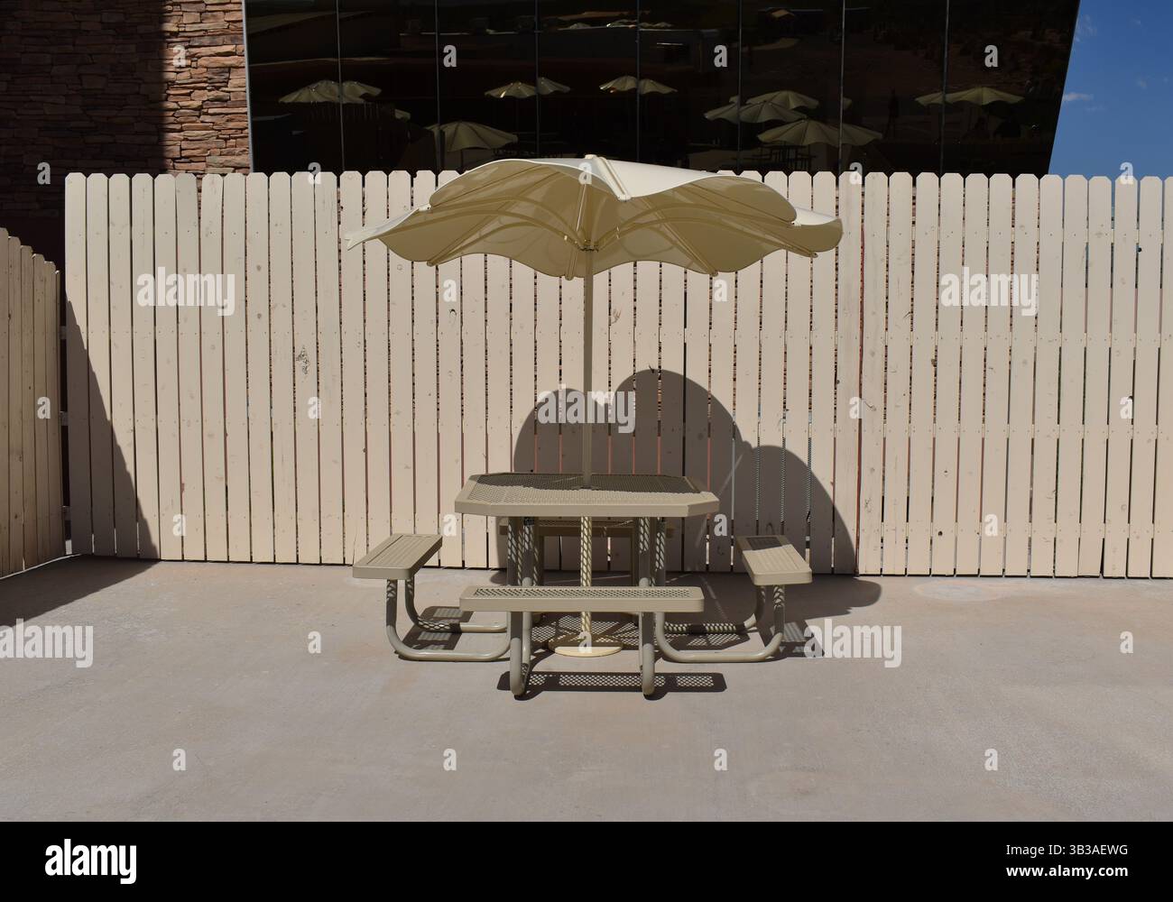 Empty cafe tables with benches and sun umbrellas under the blazing sun ...