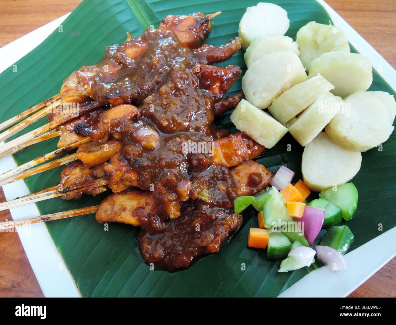 Indonesian Sate Ayam or Chicken Satay with lontong rice cake served on ...