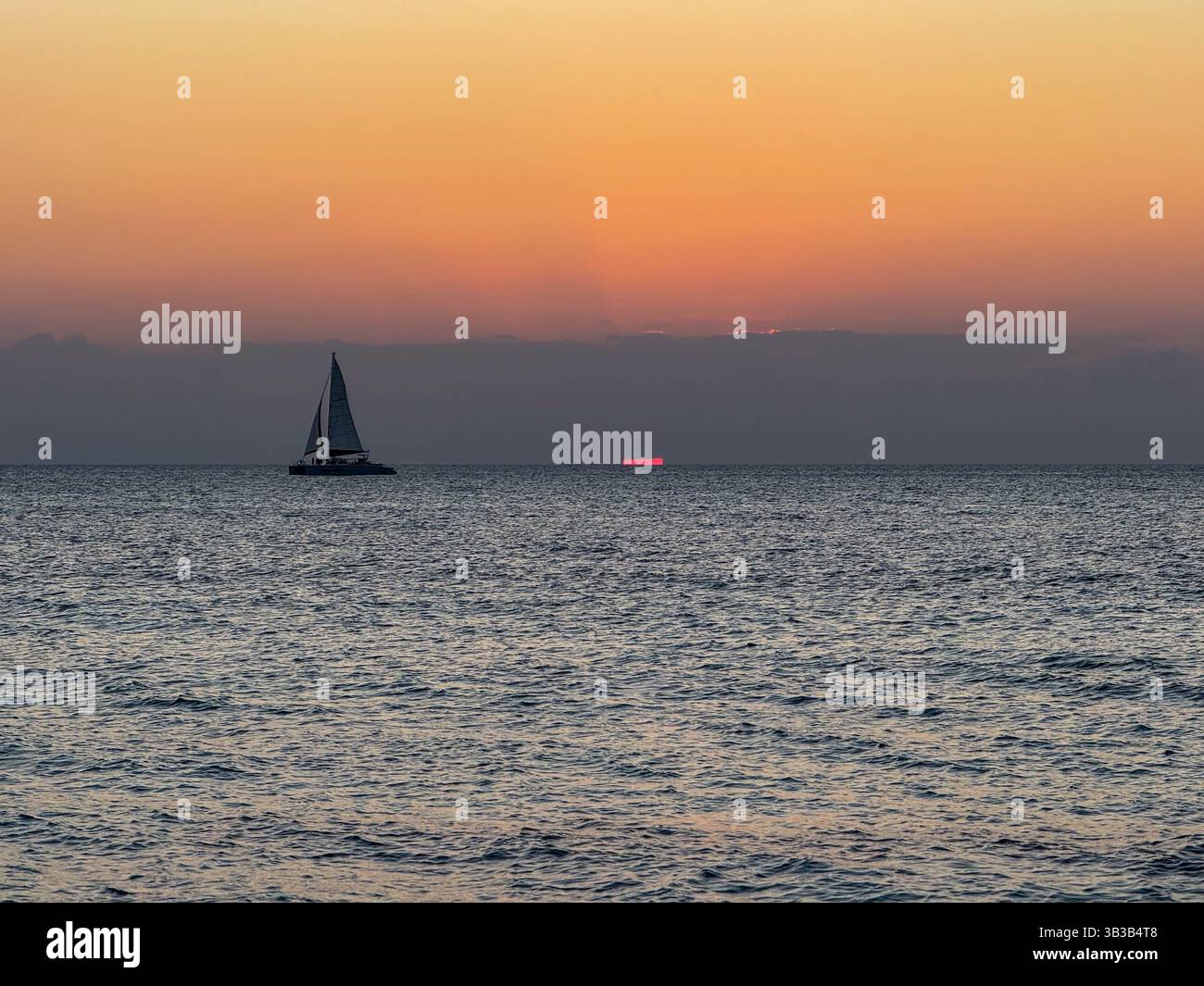 Yacht at sunset from Seven Mile Beach in Grand Cayman, Cayman Islands ...