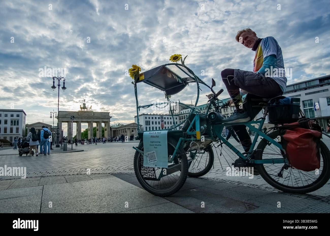 Rickshaw driver waits for new passengers near the Brandenburg Gate, a ...