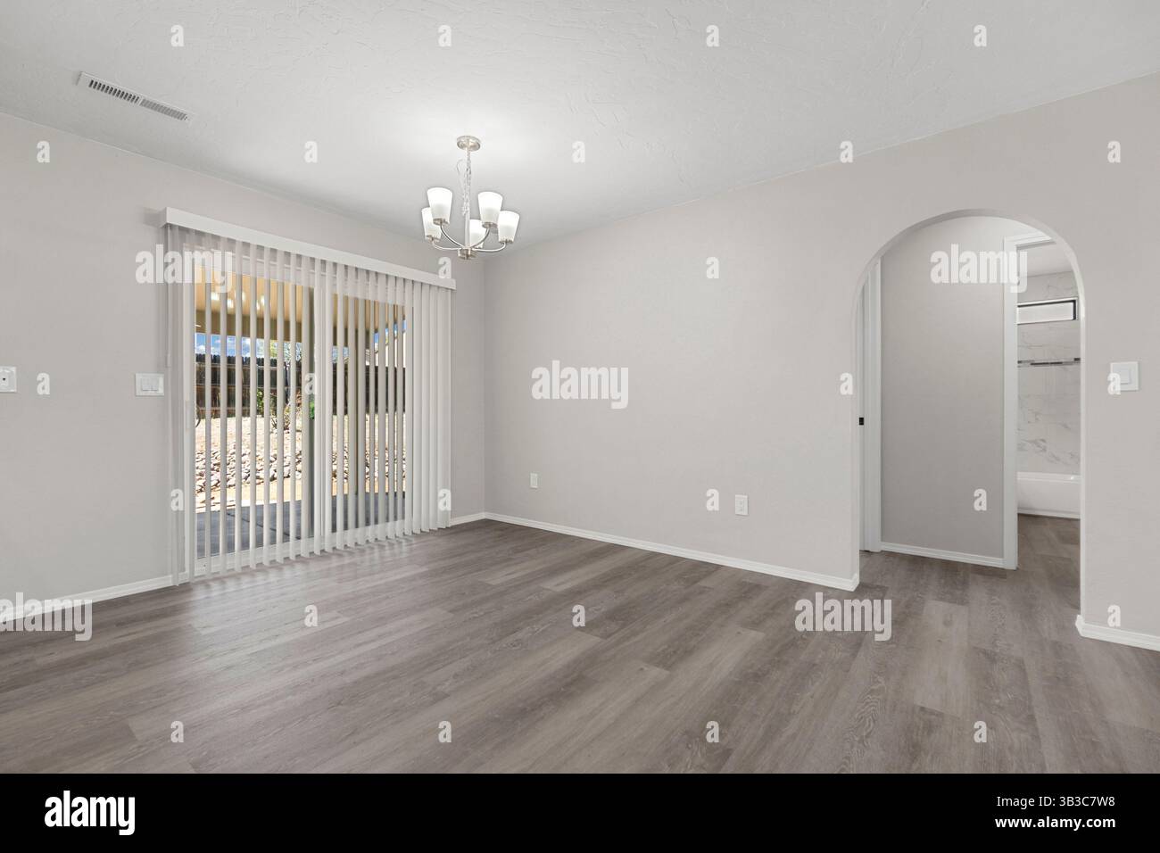A vacant living room featuring hardwood floors and sliding doors Stock ...