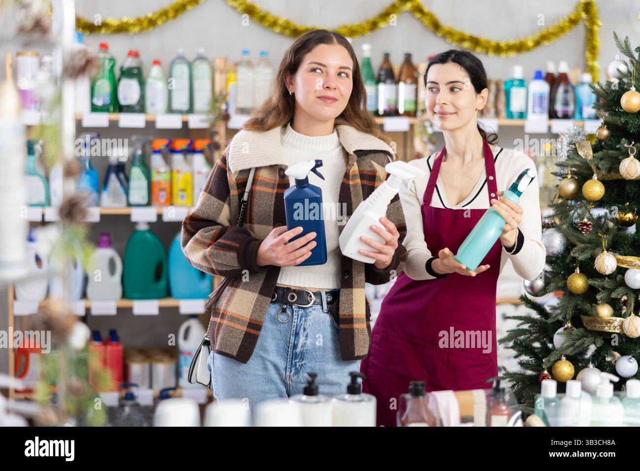 Woman seller offers cleaning spray to young woman buyer Stock Photo - Alamy