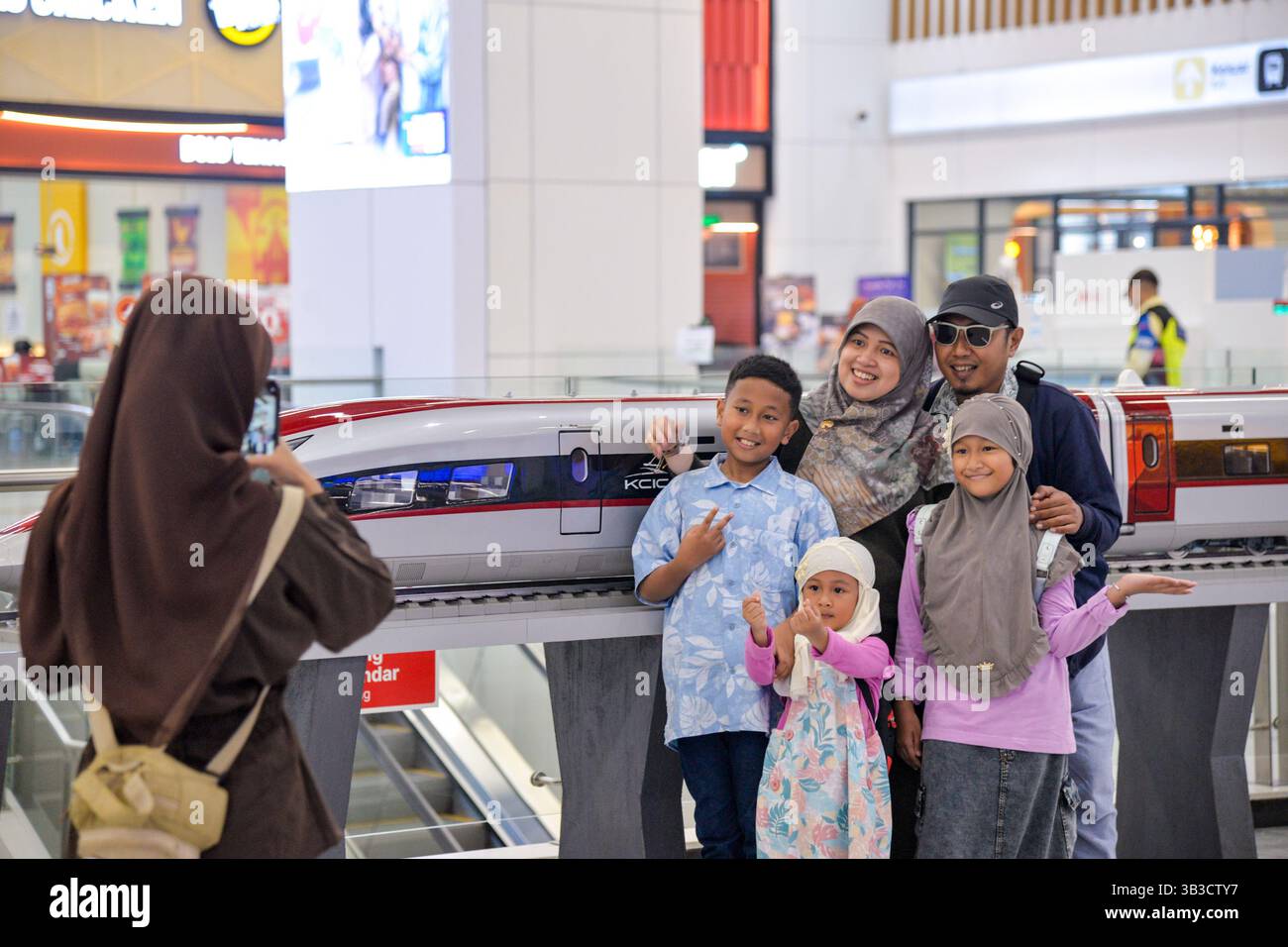 (250428) -- JAKARTA, April 28, 2025 (Xinhua) -- Passengers pose for photos with a model of a ...