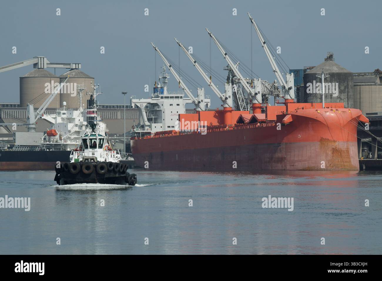 Tugboat sailing past cargo ships, docks of Durban harbour, commercial ...