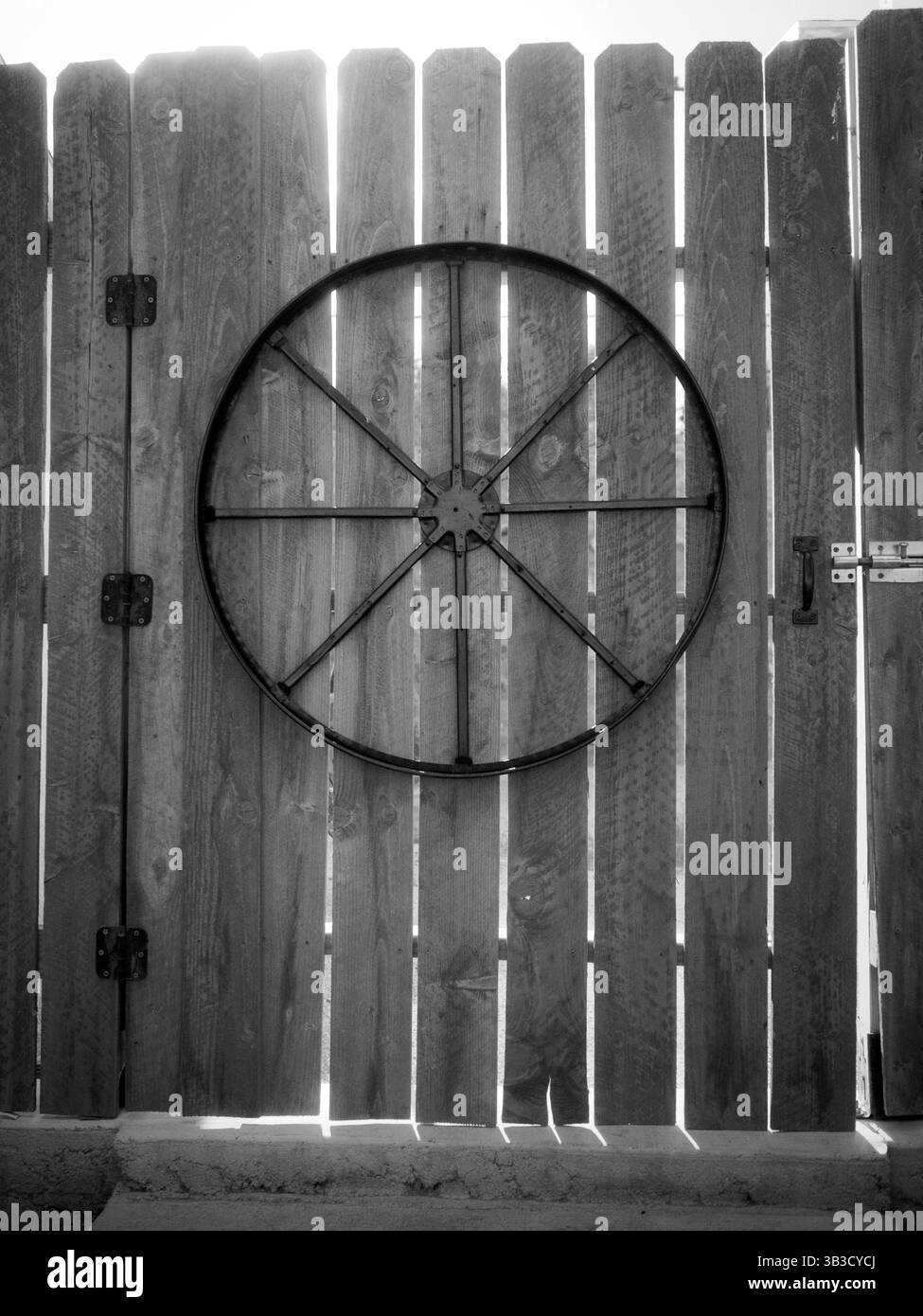 Vintage Wagon Wheel decoration on a wooden fence gate Stock Photo - Alamy