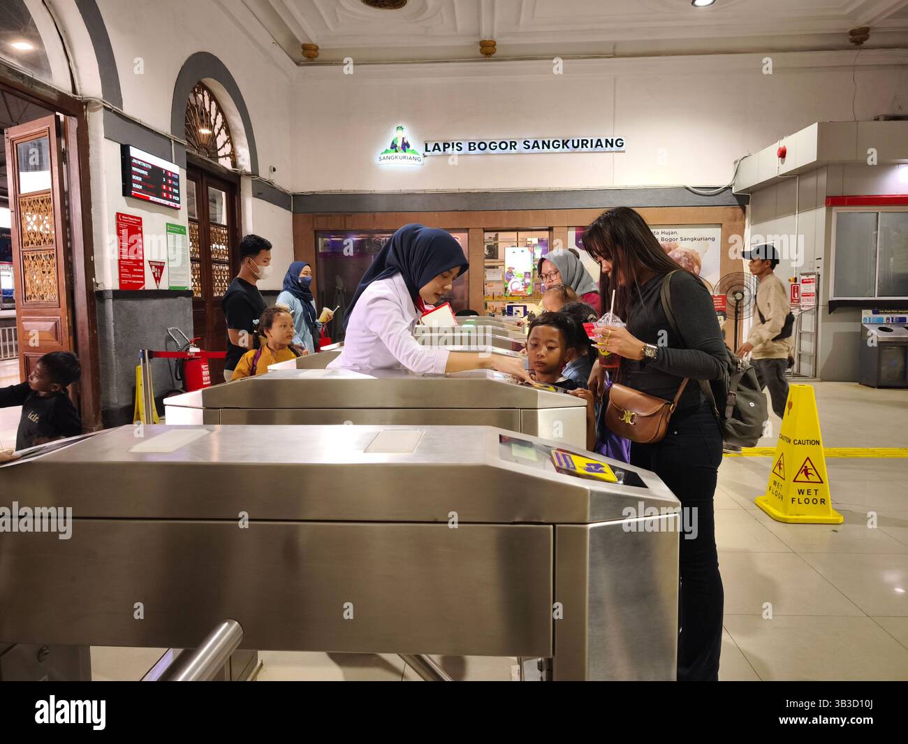 A female ticket officer helps prospective passengers use their cards to ...