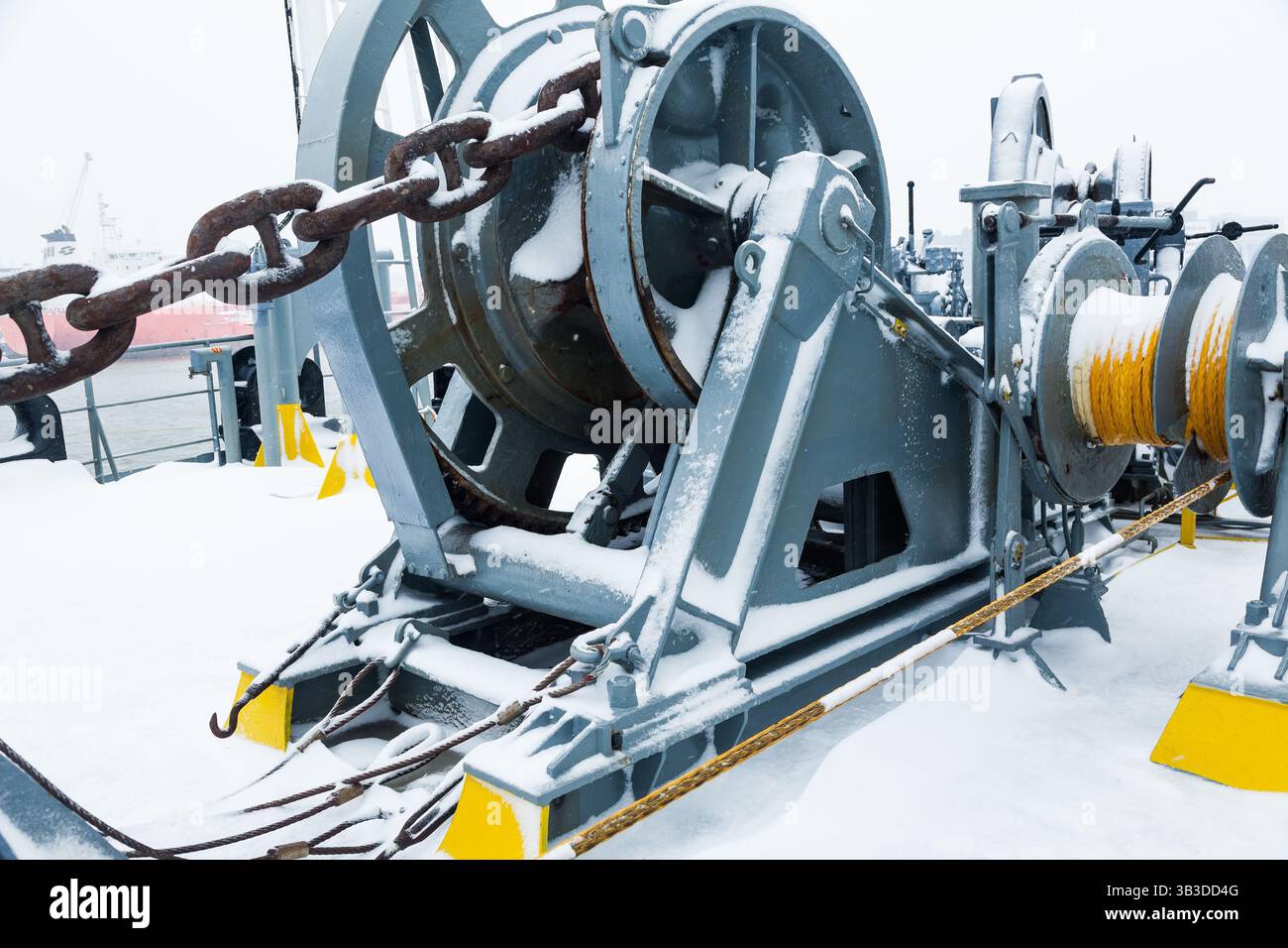 The mooring deck of a cargo ship with anchor winches, an anchor chain ...
