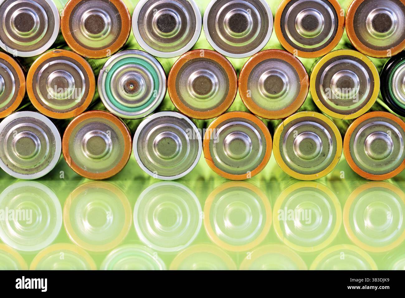 Multiple used AA alkaline batteries are seen arranged in a pile on a ...