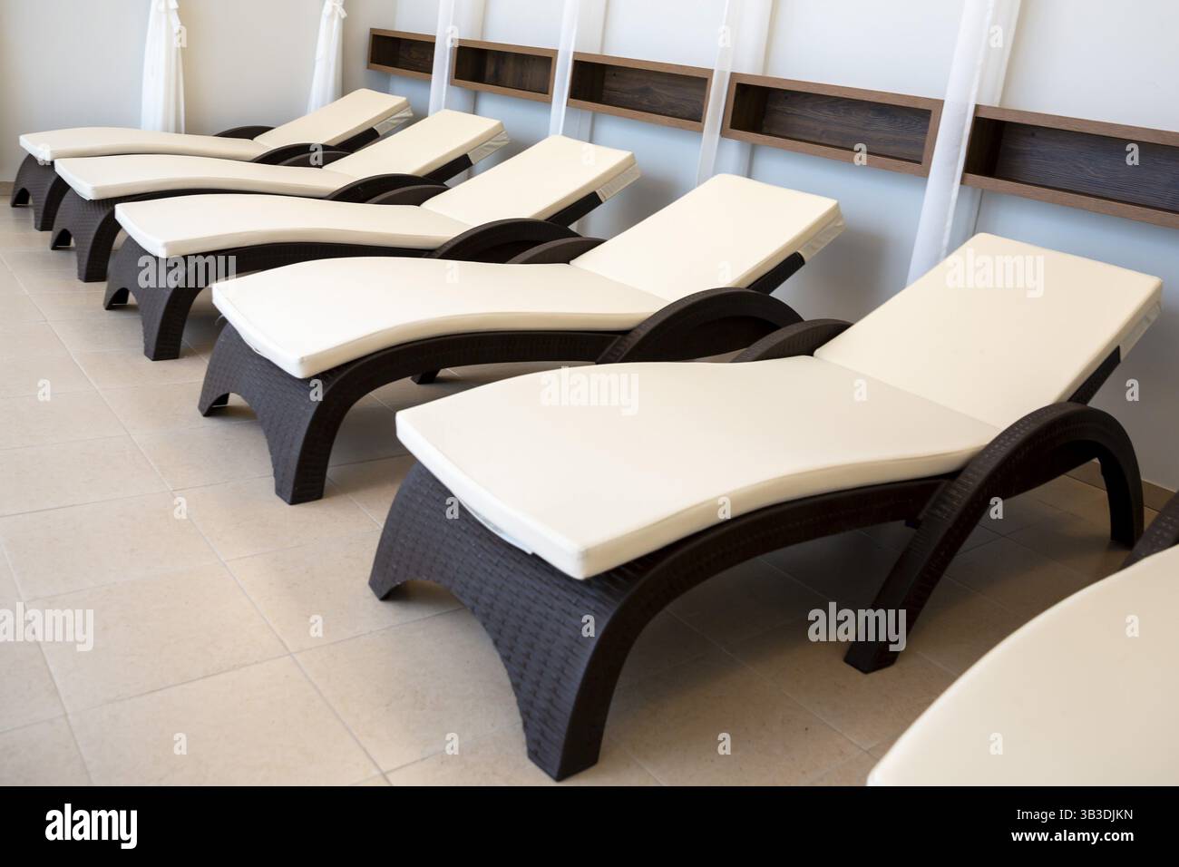 Deck chairs in a row for a relaxation in a spa center Stock Photo - Alamy