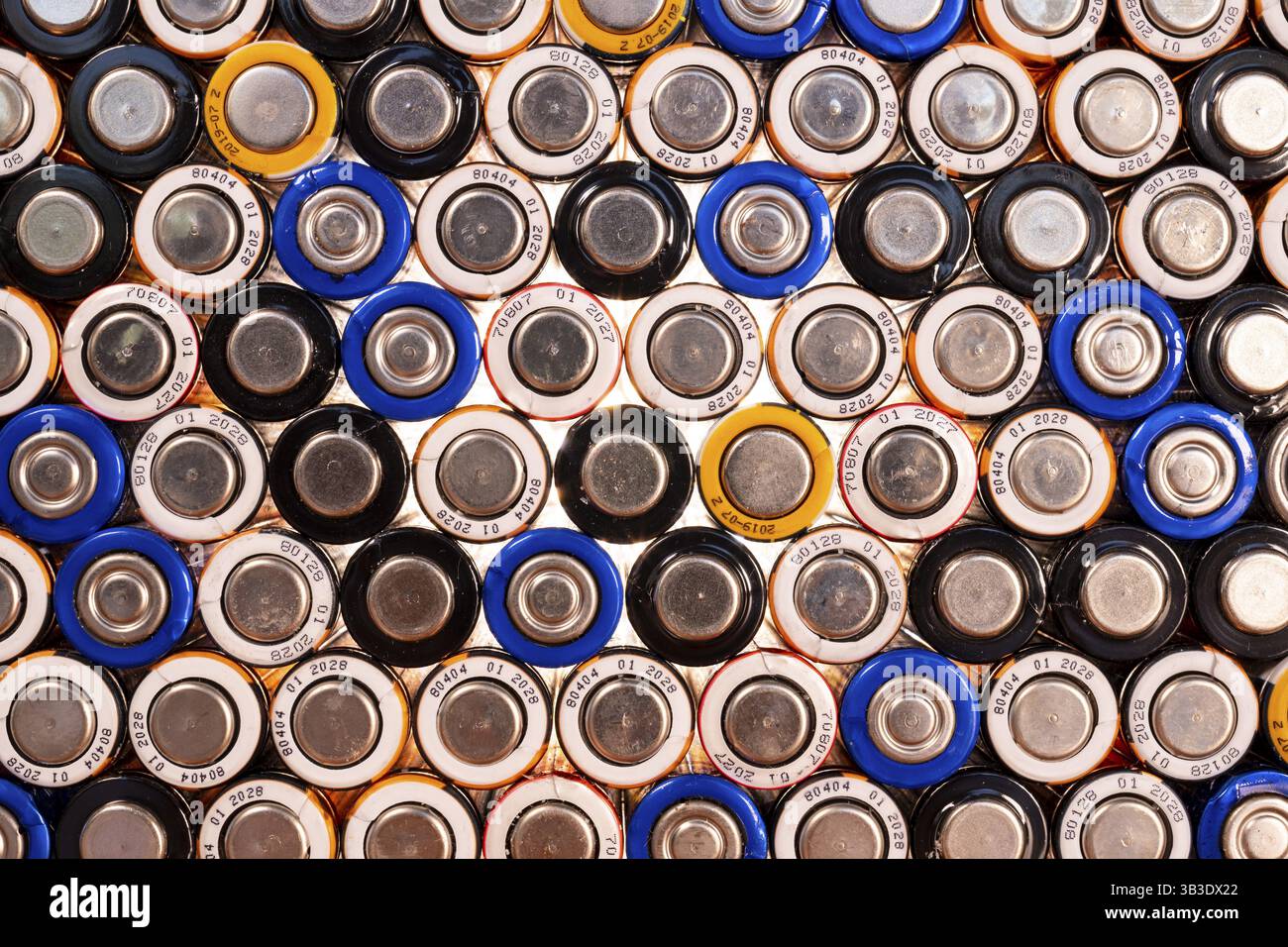 Multiple used AA alkaline batteries are seen arranged in a pile ...